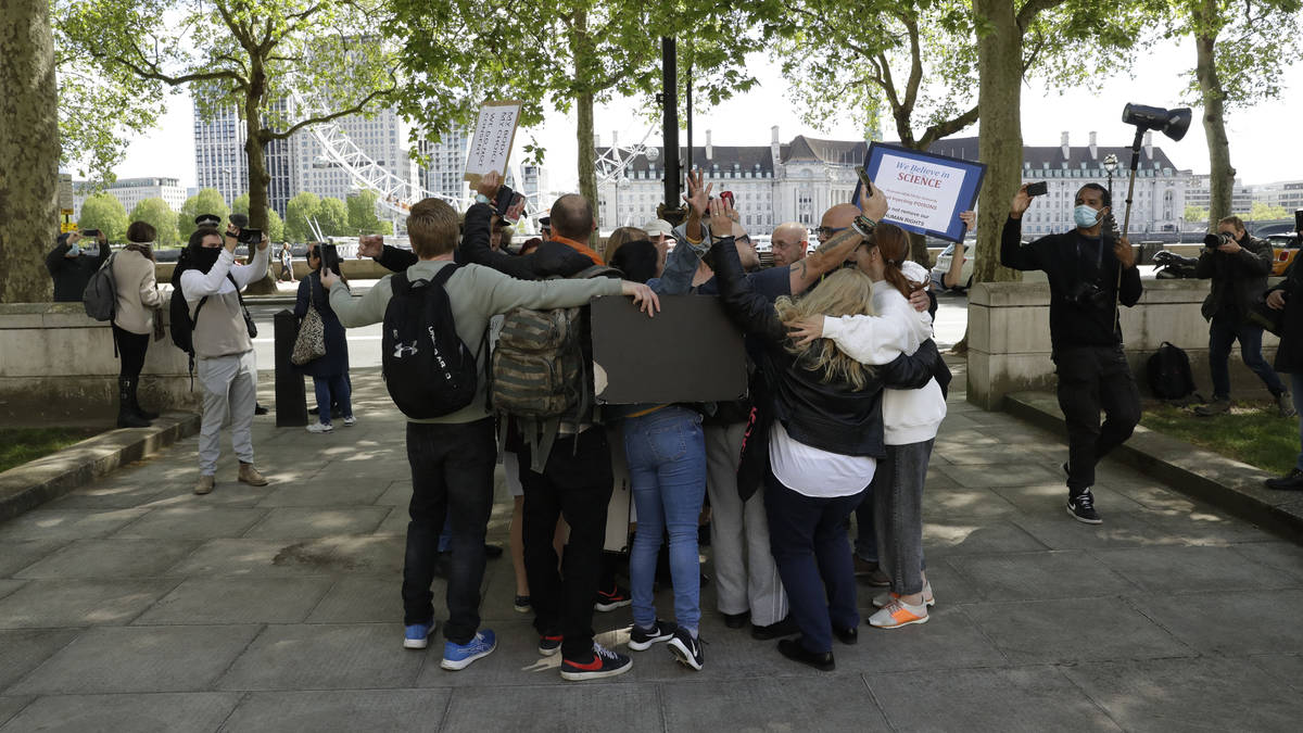 Protesters hug in defiance of coronavirus lockdown outside police HQ | LBC